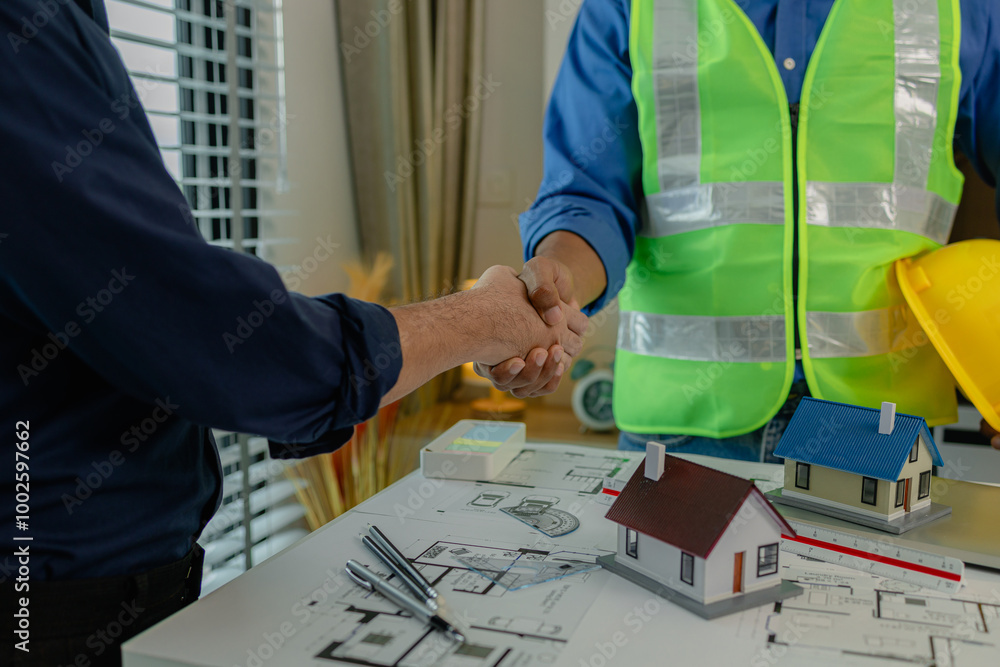 engineer and architect are shaking hands to celebrate because they just ...