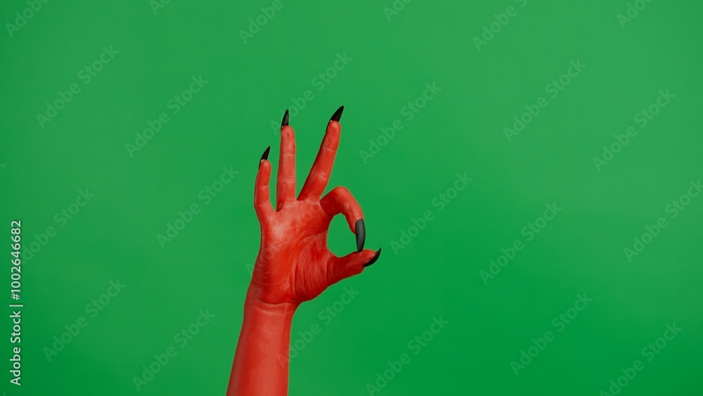 Creepy halloween devil monster hand in red paint with black nails shows ...