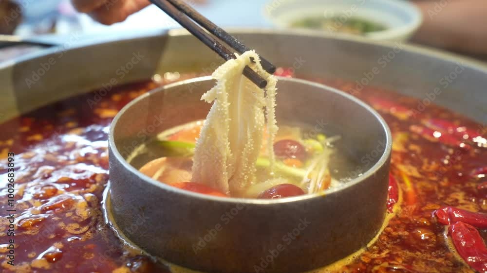 Close up slow motion of people having hotpot typical spicy Sichuan food ...