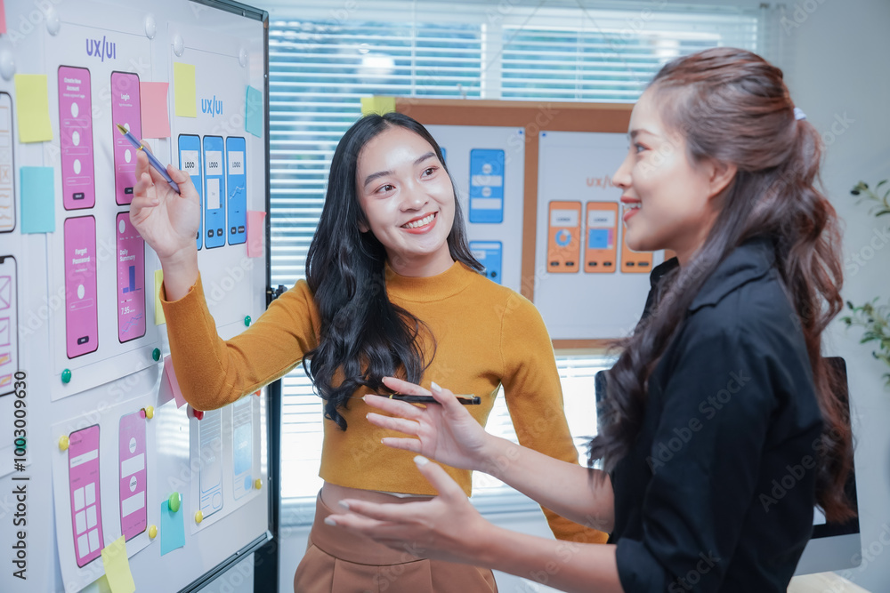 Two Asian Ui Ux Designers Are Discussing Mobile App Interface Wireframe Design On Whiteboard