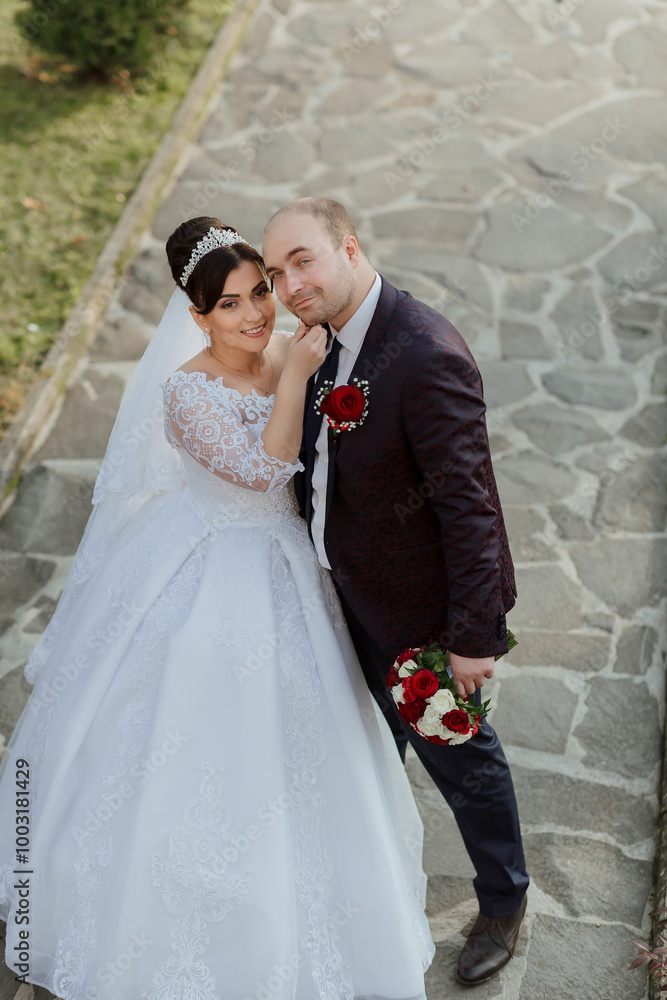 A bride and groom are posing for a picture on a stone staircase. The ...