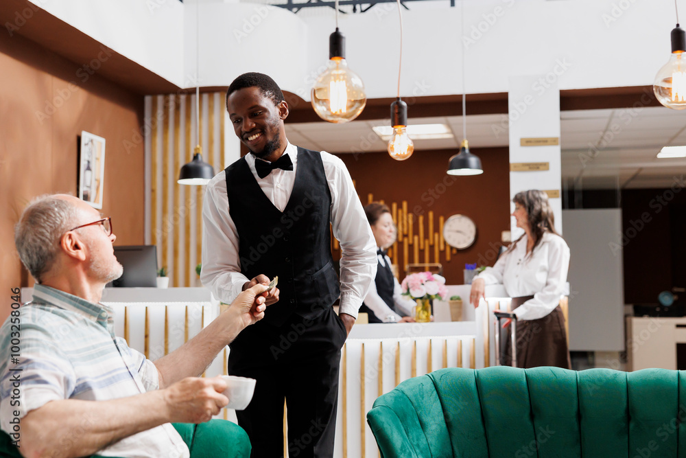 African american employee receiving money tip from eldery male tourist ...
