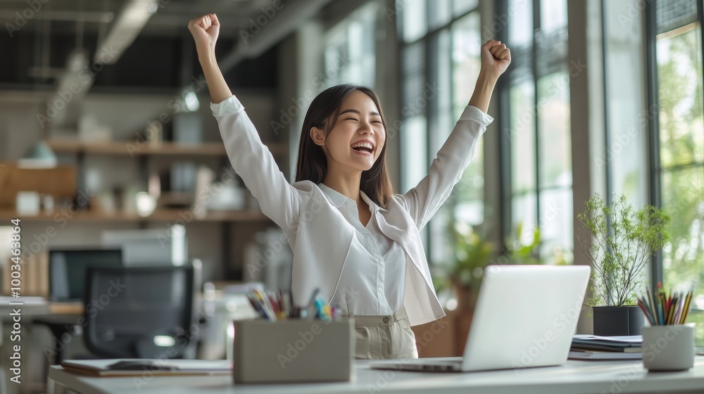 Successful young woman cheering in modern office. Young woman in a ...