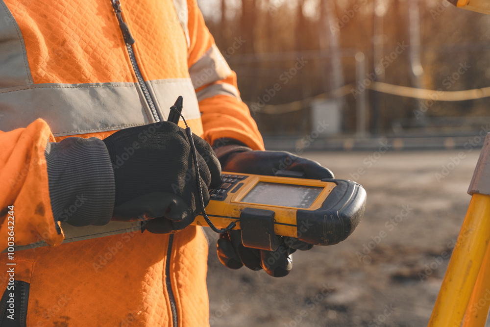 Plakát Construction worker conducting measurements with handheld device ...