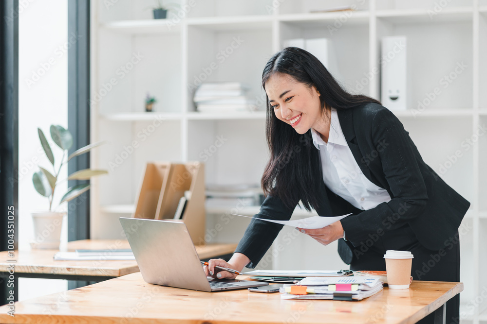 professional woman in black suit is working at desk in modern office ...