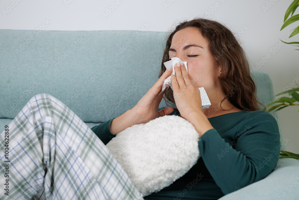 A young woman is feeling very physically unwell. Her body is heavy, she ...