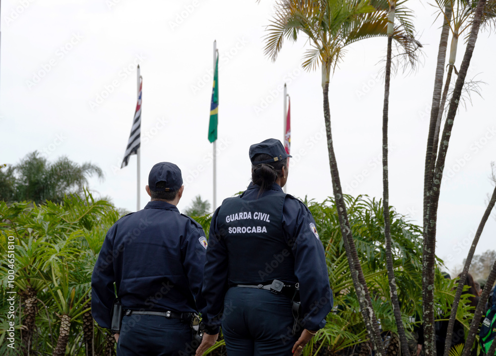 Male police officer and female police officer in front of the flags of ...