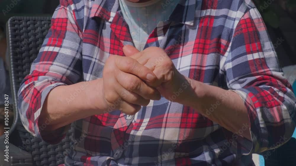 An elderly woman with arthritic joints rubs her hands. An old granny ...