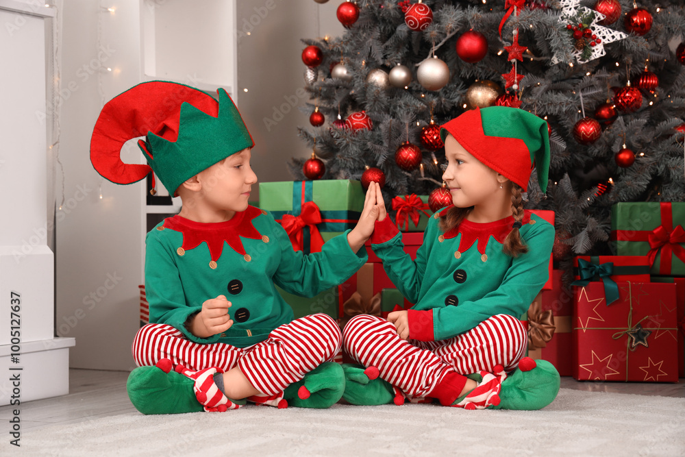 Cute little children in elf costumes giving each other high-five at ...