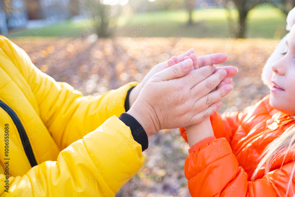 child's hands frozen, mother warms, rub cold palms girl on walk ...