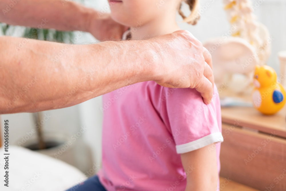 male Orthopedist doctor conducts spinal examination child, young girl ...