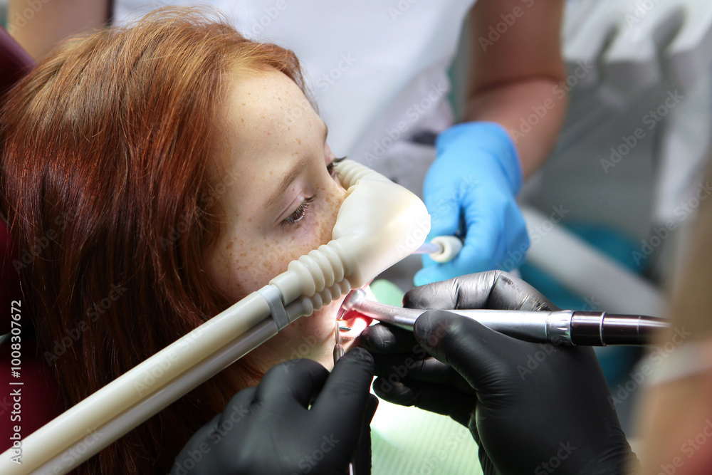 Dental treatment in a child with sedation. A little girl is injected ...