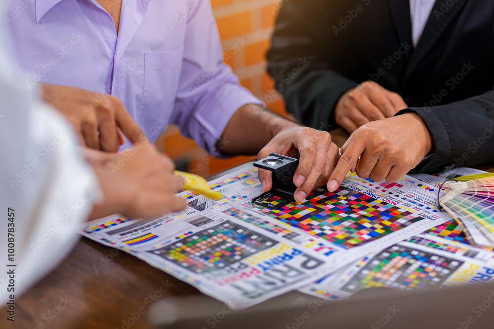 Team graphic designer checking print quality of media graphics proof ...