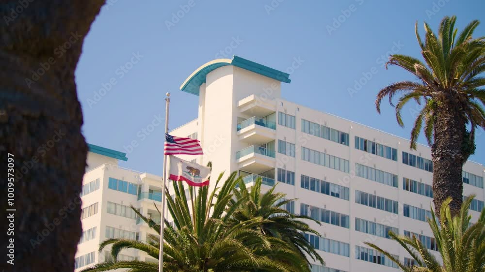 Modern white apartment building with palm trees and flags. Flags of USA ...