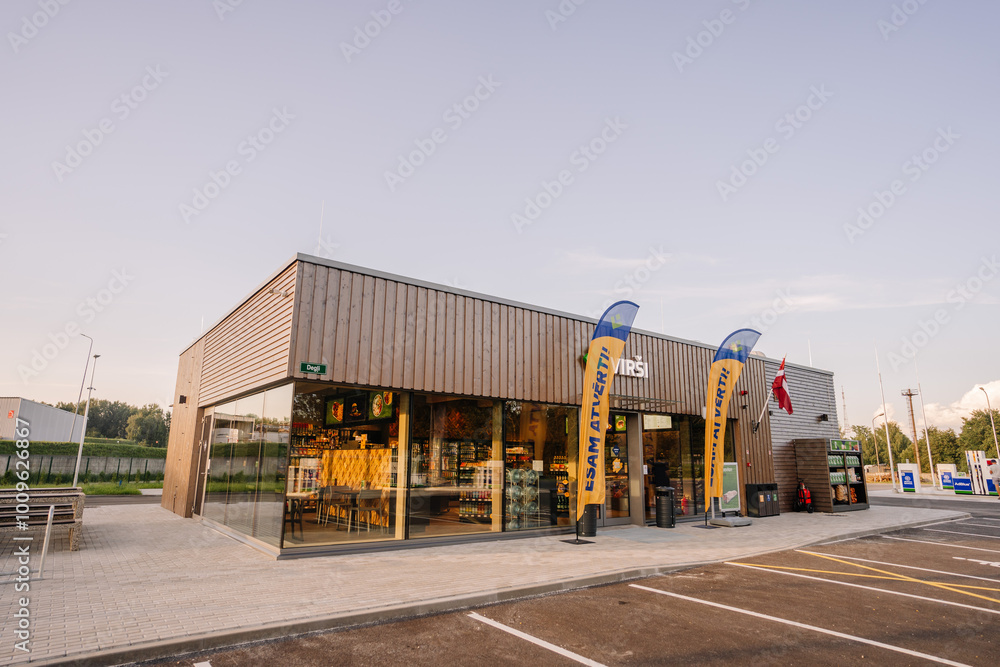 A modern Virši gas station convenience store with glass walls, flags ...