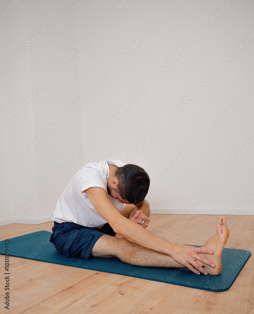 White Latino male performing the open pincer pose (Prasarita ...