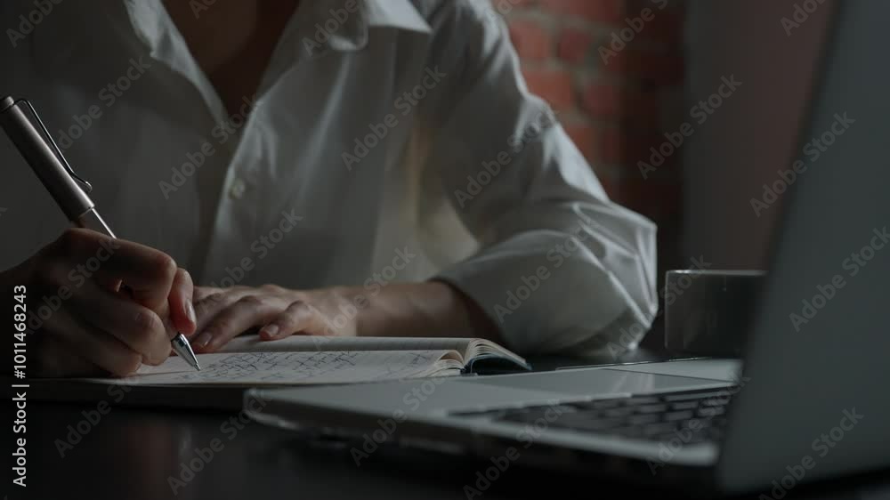 Business woman sitting at office desk with laptop writing notes in ...