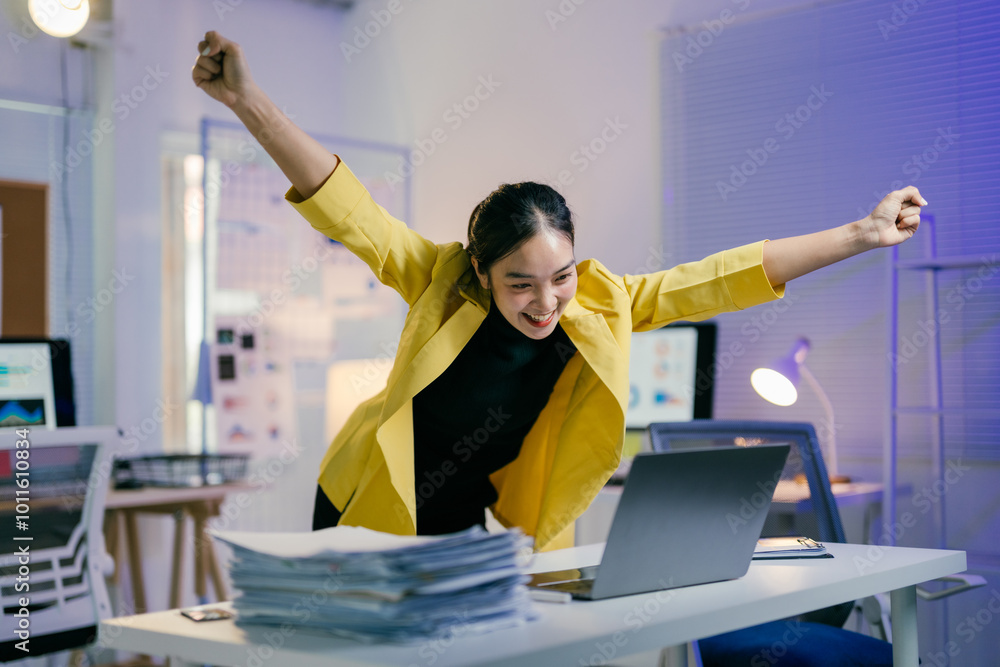 Young professional woman in a modern office celebrates success at work ...