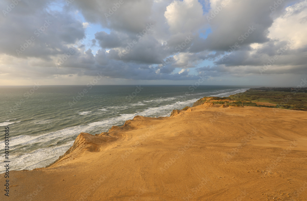 sandy cliff crumbling away under the relentless power of the natural ...