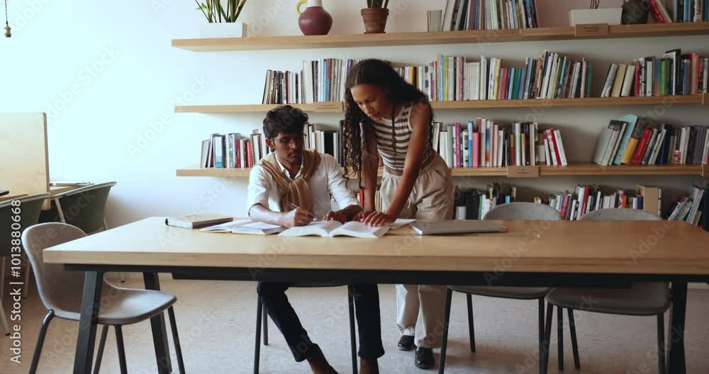 African American student girl helping Indian classmate guy with home ...