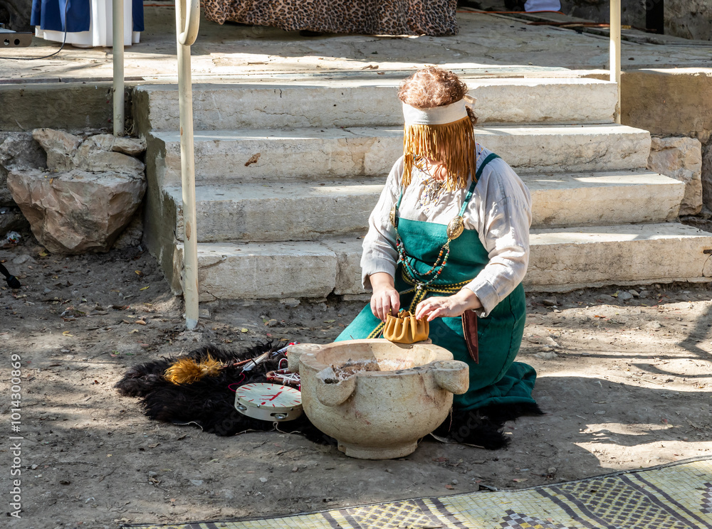 An artist dressed as a witch gives a performance at the annual festival ...