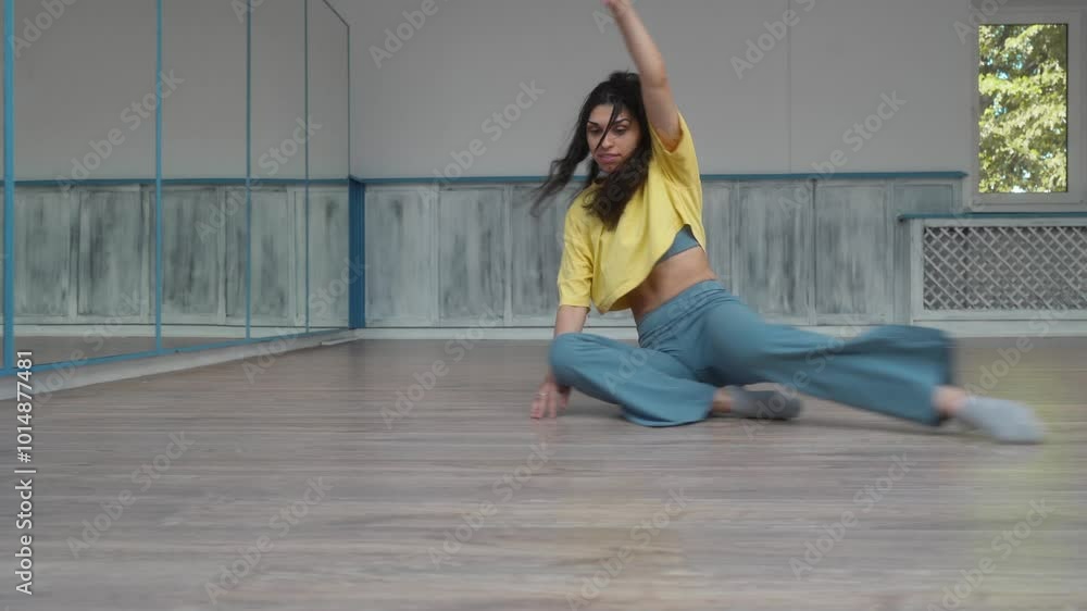 The dancer dances sitting on the floor, legs wide apart and making ...