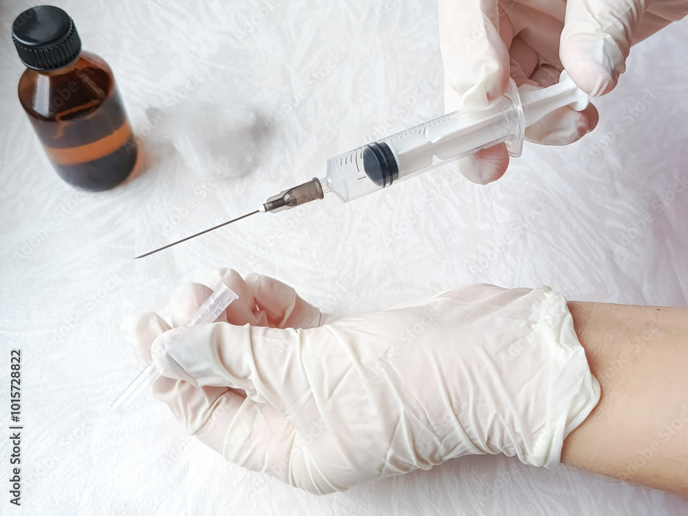 Hands in medical gloves remove cap from syringe needle. Opening syringe ...