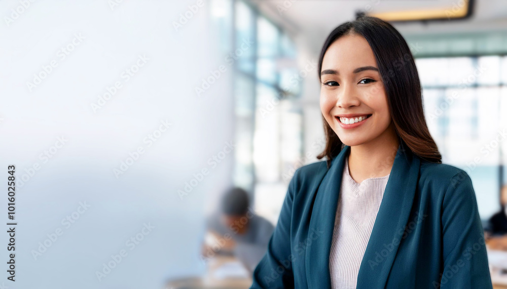 businesswoman in a modern office setting. She is smiling, dressed in ...