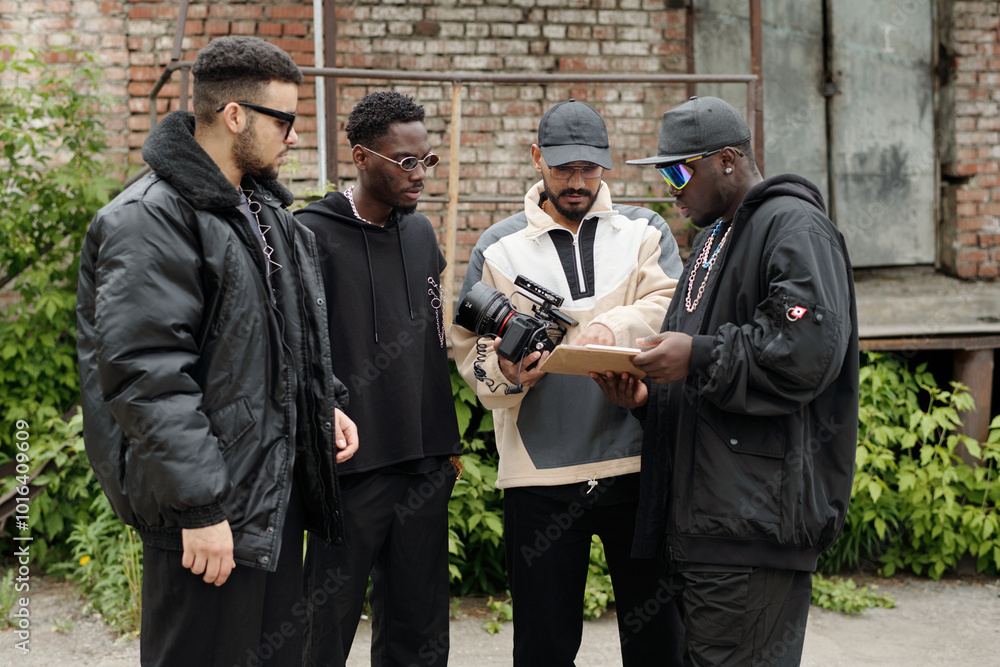 Group of filmmakers collaborating, discussing filming details outside ...