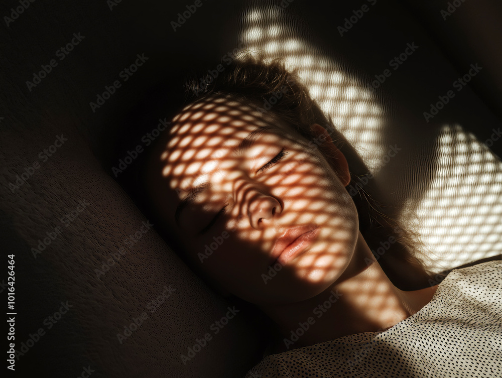 Artistic shadows cast on a sleeping woman’s face, creating a pattern of ...