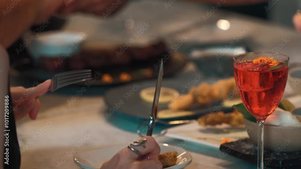 Focusing Cosmopolitan cocktail decorated by flower with cropped group ...