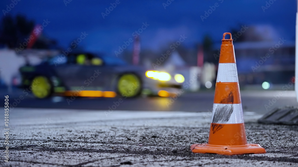 Professional race car passing behind the road cone on race track at ...