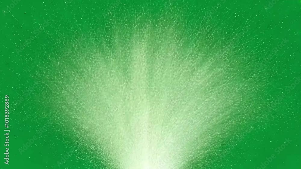 Water bursts upward in slow motion against a vivid green screen ...