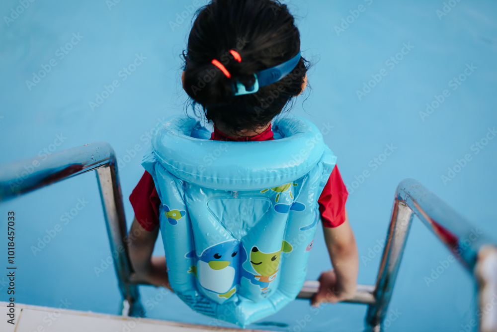 girl sitting on the swimming pool steps, using a float, Girl sitting at ...