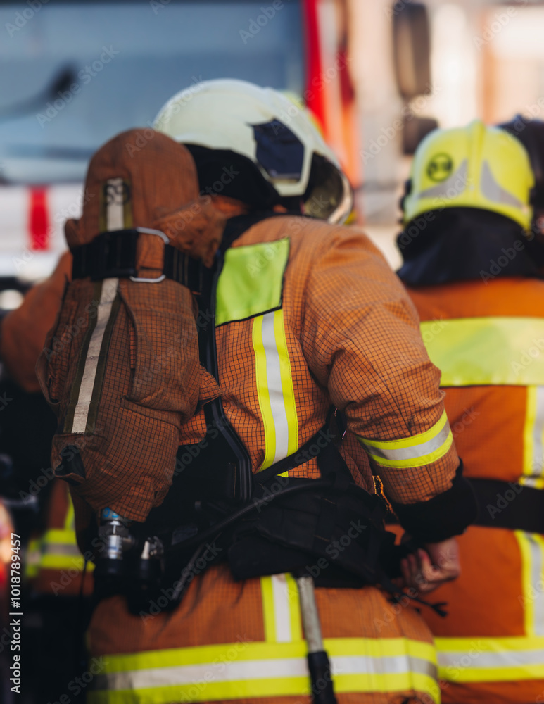 Group of fire men in uniform during fire fighting operation in the city ...