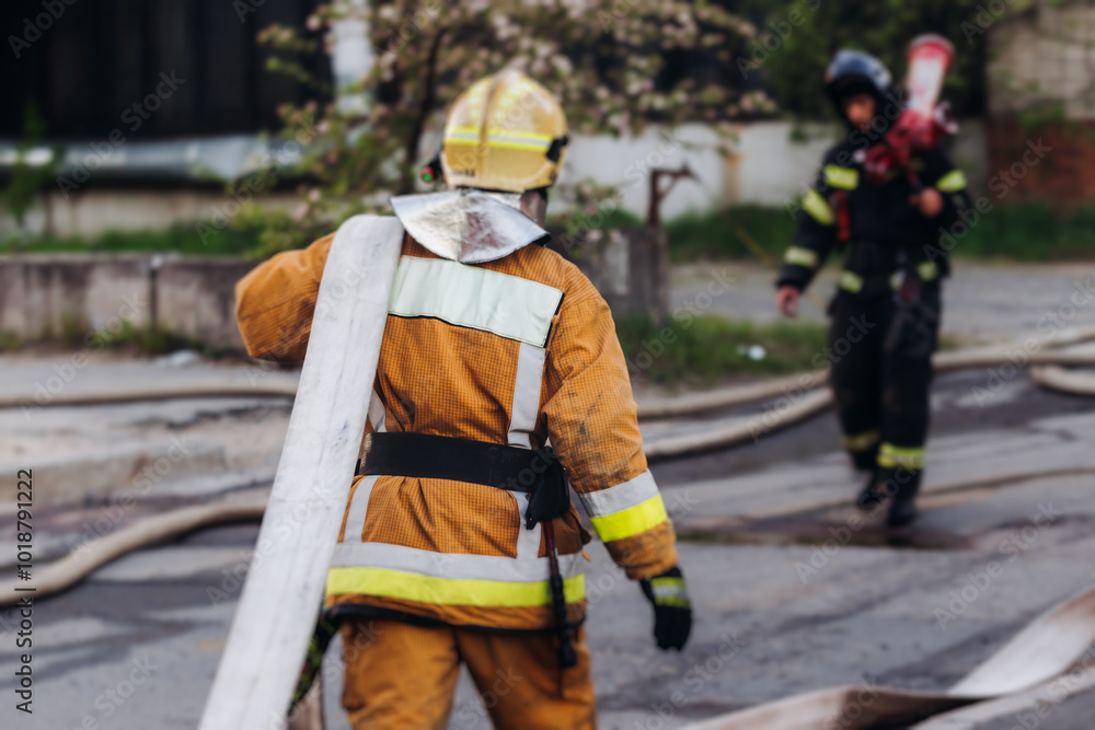Group of fire men in uniform during fire fighting operation in the city ...
