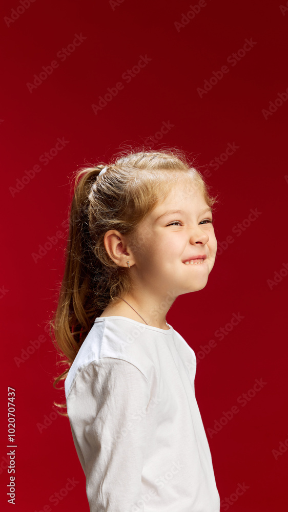 Smiling with scrunched nose, girl gives cheeky grin, making her look ...