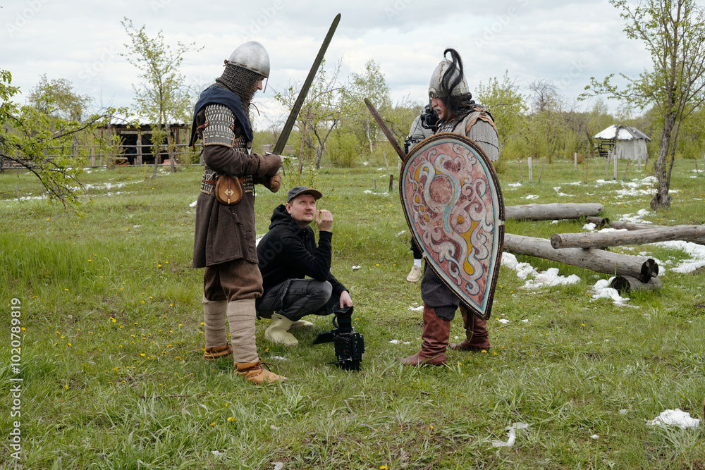 Historian listening to two reenactors dressed as medieval warriors with ...