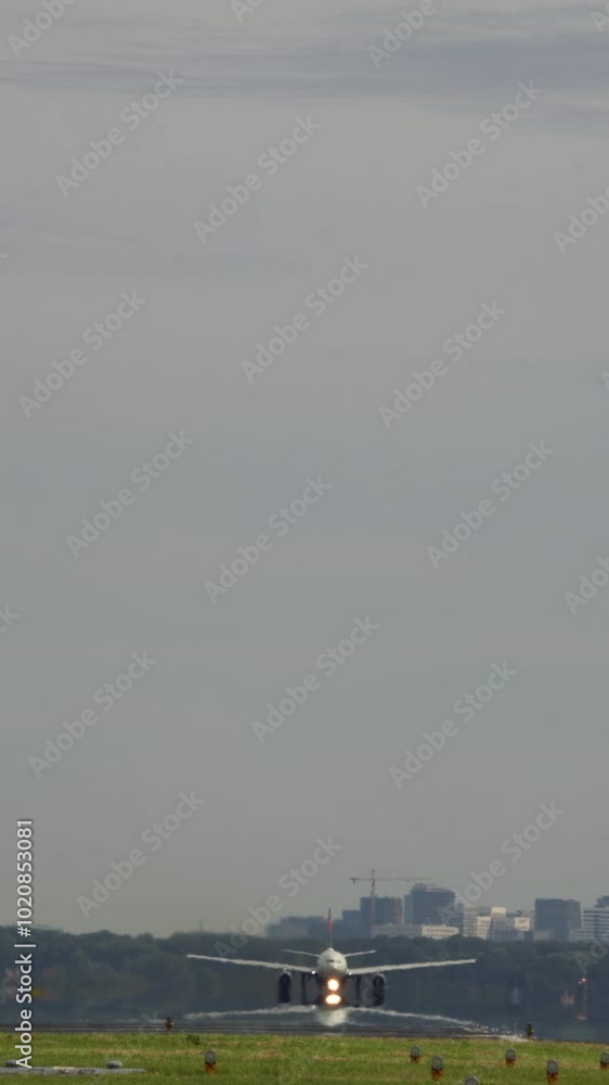 Vertical video of a large passenger airplane taking off from the runway ...