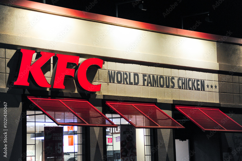 Exterior night view of a KFC restaurant displaying its brand logo and ...