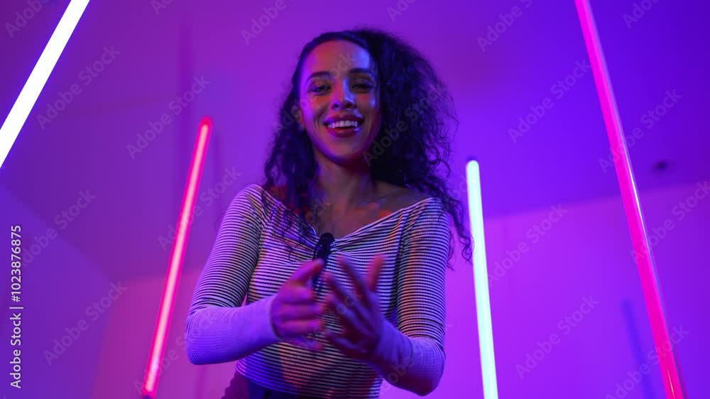 Low angle camera of hispanic dancer looking at camera and dancing to ...