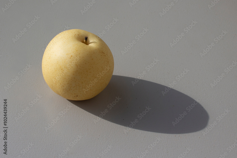 an Asian pears are placed on a grey painted viva board. The round Asian ...