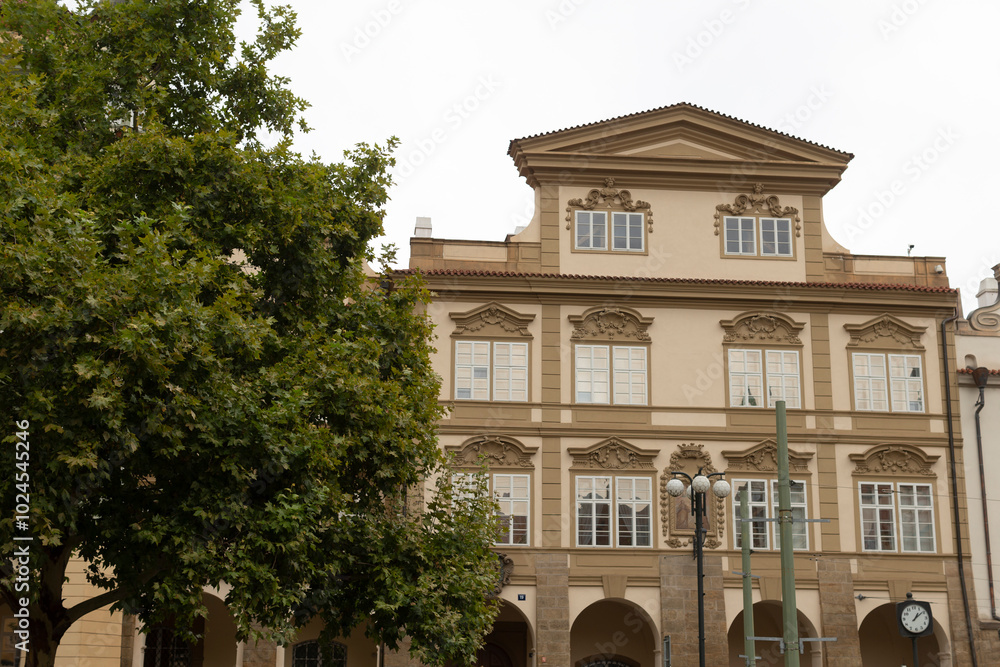 In front of a large, impressive building, there is a beautiful green ...