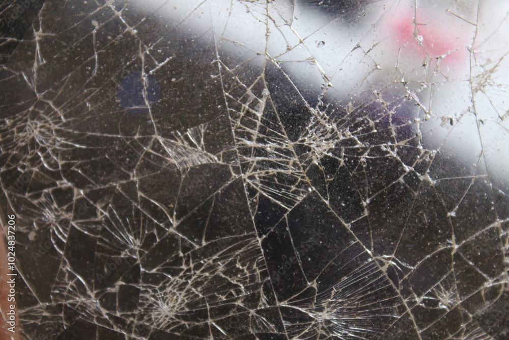 Cracked glass surface revealing intricate web of fractures and ...