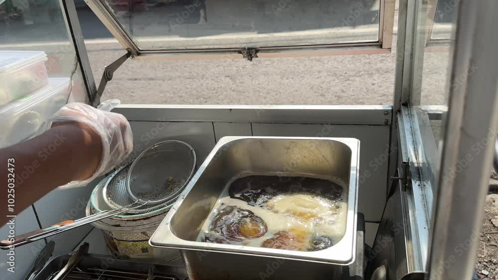 Street food vendor frying food in hot oil at a small cart Stock Video ...