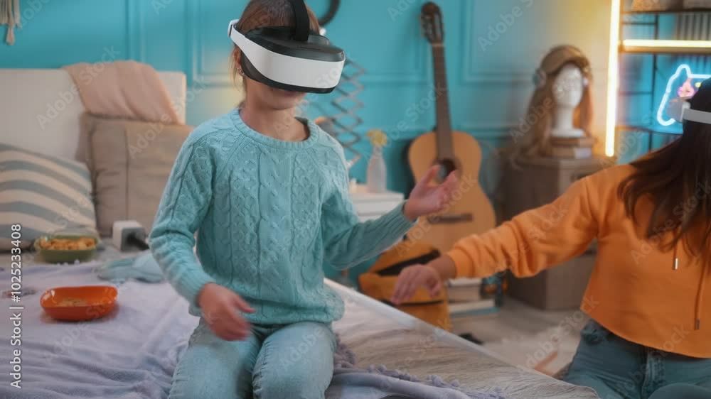 A little girl child of 10 years wears a VR headset and dances while ...