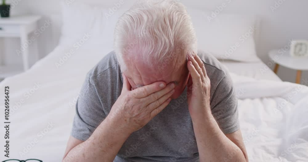 Tired frustrated old senior man touching head, feeling headache ...