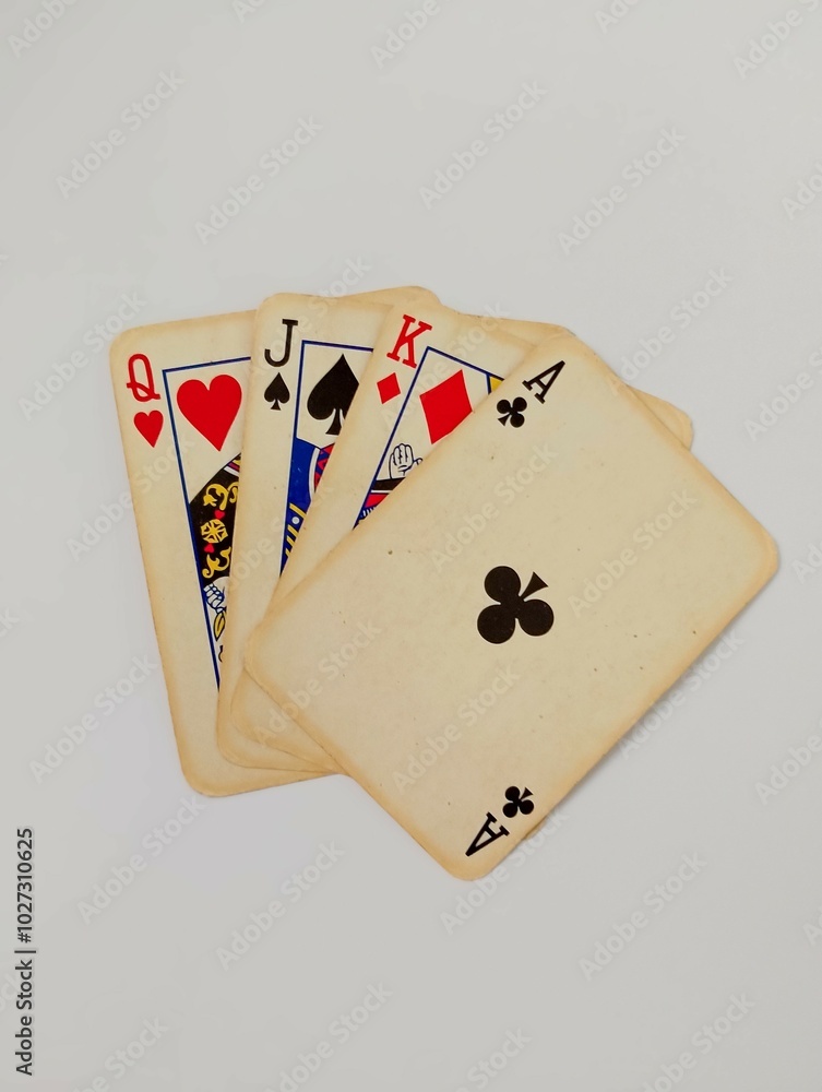 A close-up photo of four playing cards laid out on a white background ...
