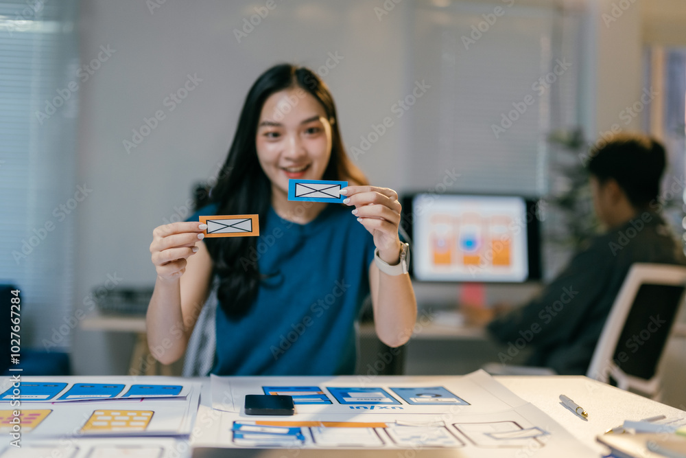 Young asian designer woman is holding two different options for a ...