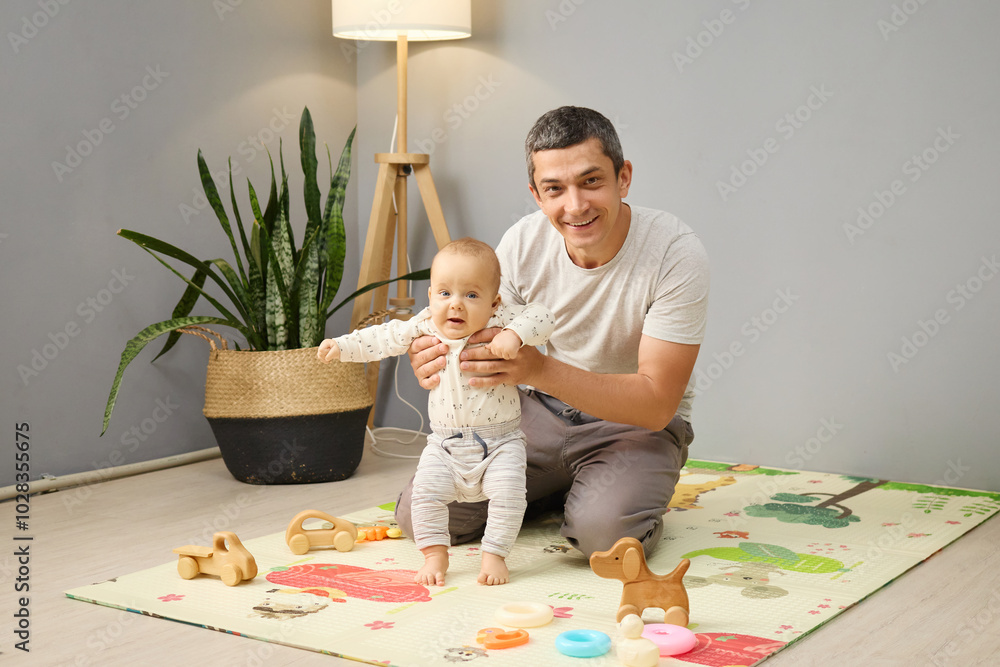 Smiling father testing muscle tone showing care and support during ...